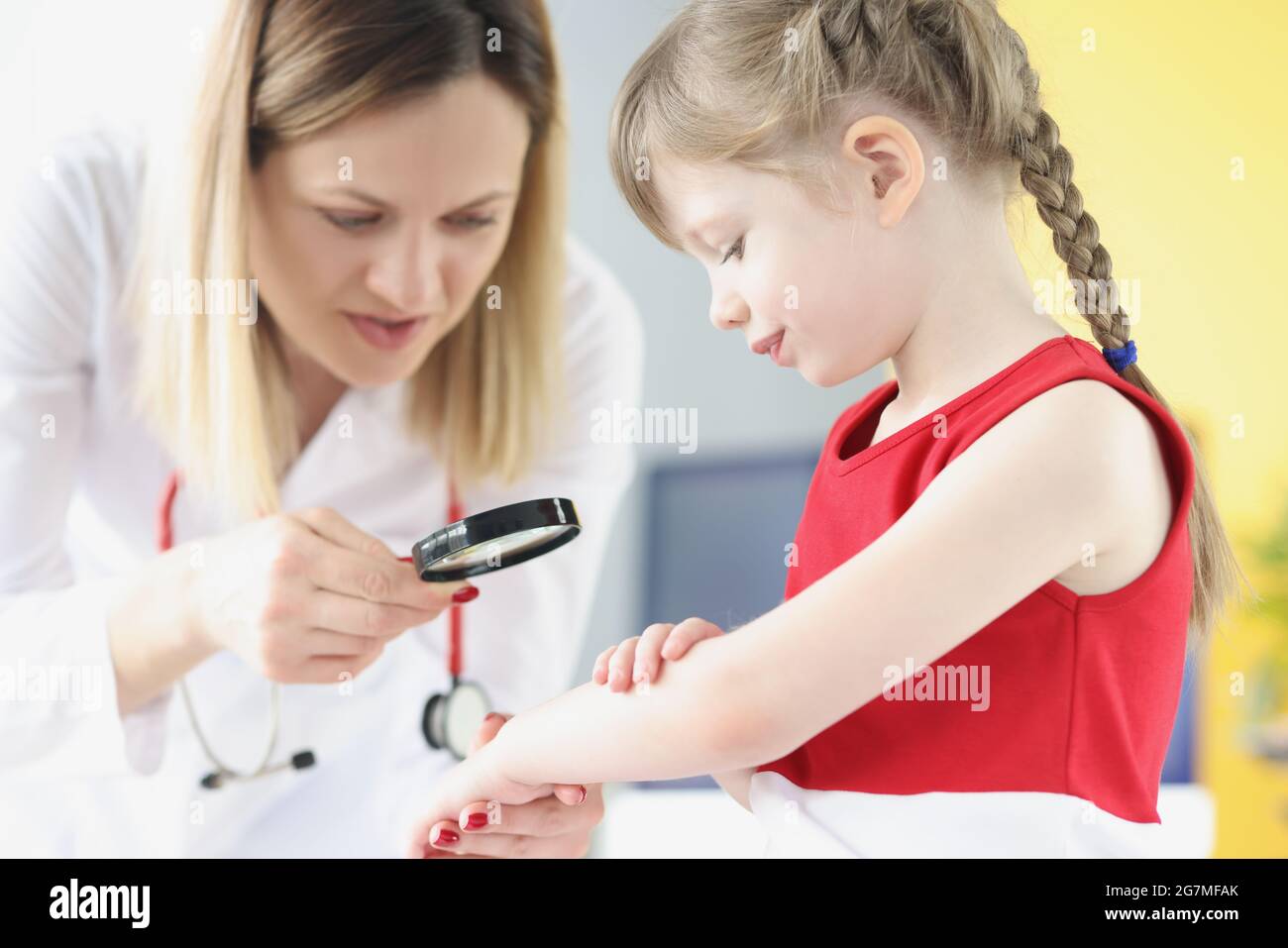 Doctor pediatrician examining rash on skin of hand of little girl using ...