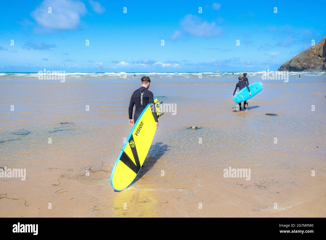 Mawgan Porth beach in Cornwall UK; holidaymakers carrying their hired ...