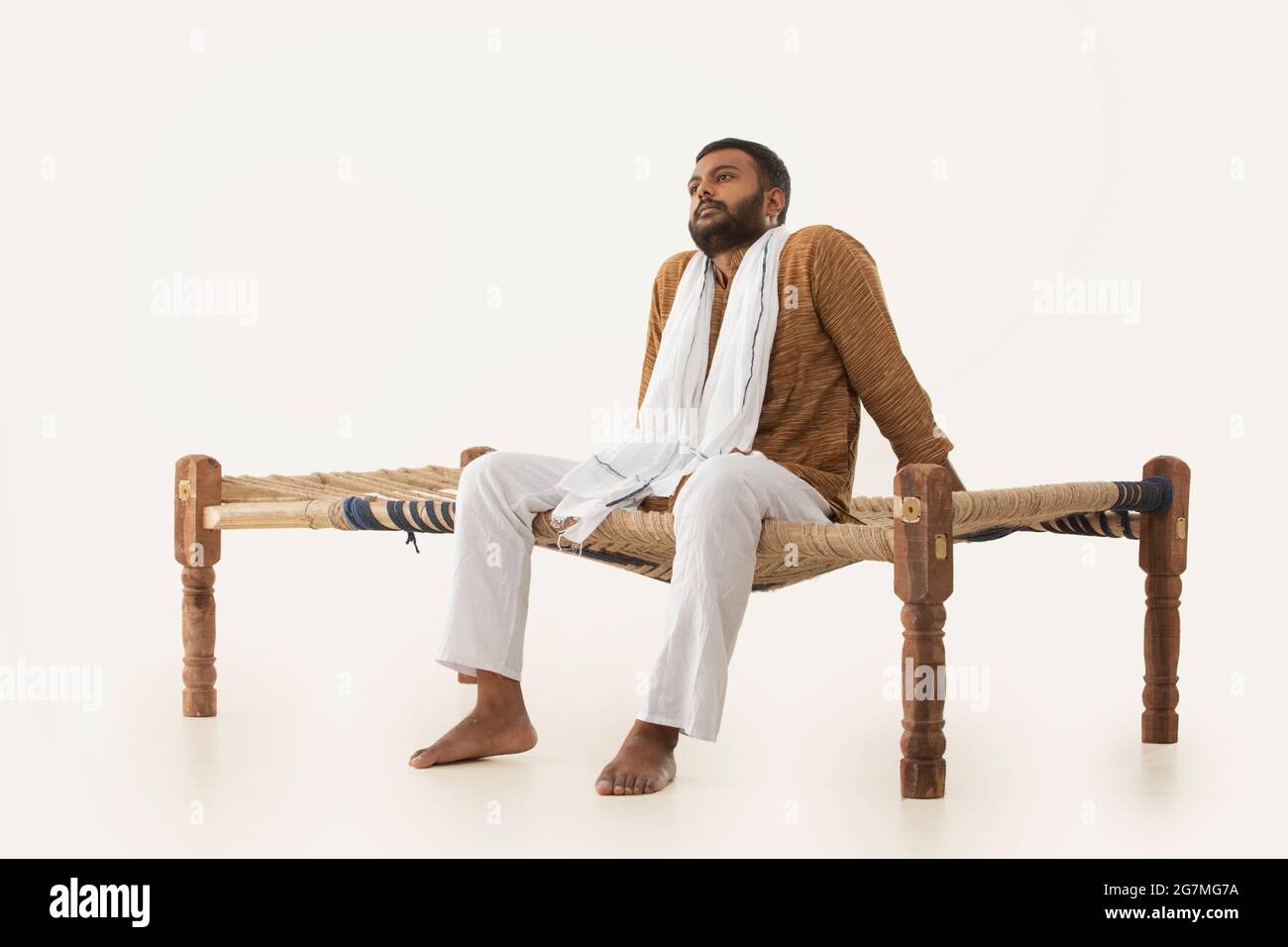 PORTRAIT OF A RURAL MAN SITTING TIRED ON A COIR COT Stock Photo - Alamy