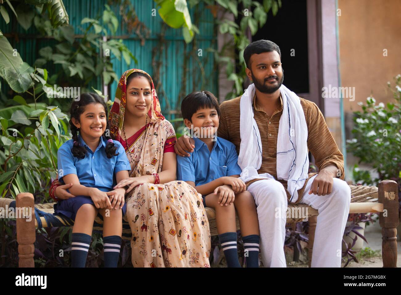 PORTRAIT OF A HAPPY RURAL FAMILY SITTING OUTSIDE ON A COIR COT Stock ...