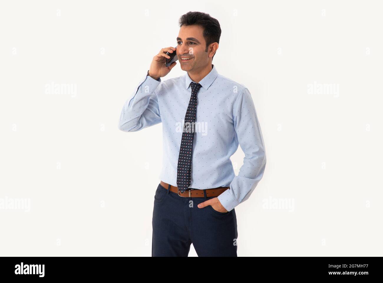 A CONFIDENT CORPORATE PROFESSIONAL STANDING AND TALKING ON MOBILE PHONE ...