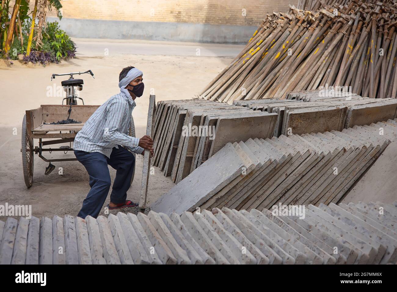 A LABOURER CARRYING LARGE BLOCK OF TILE Stock Photo - Alamy