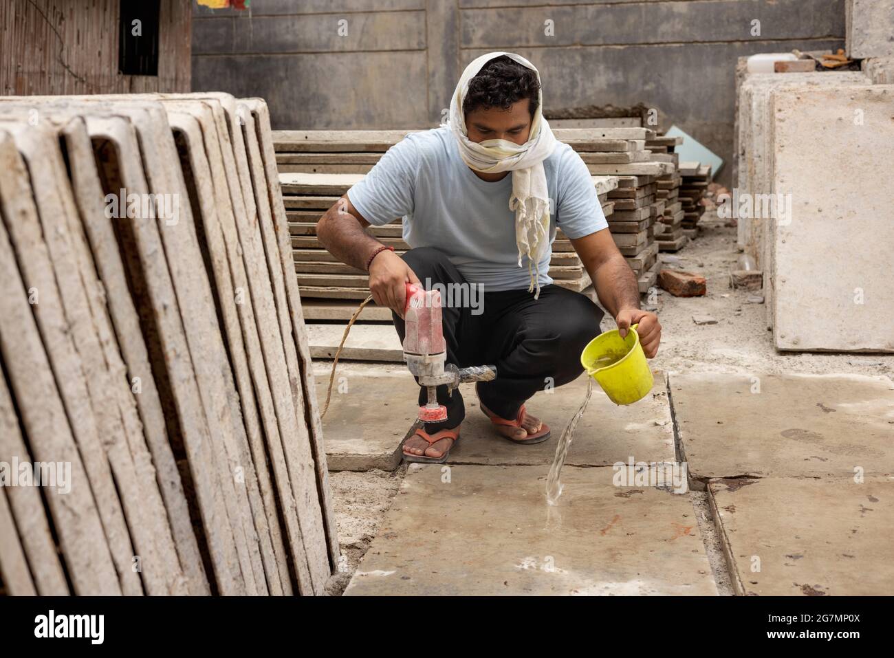 A HARD WORKING LABOURER USING ELECTRIC EQUIPMENT ON TILES Stock Photo ...