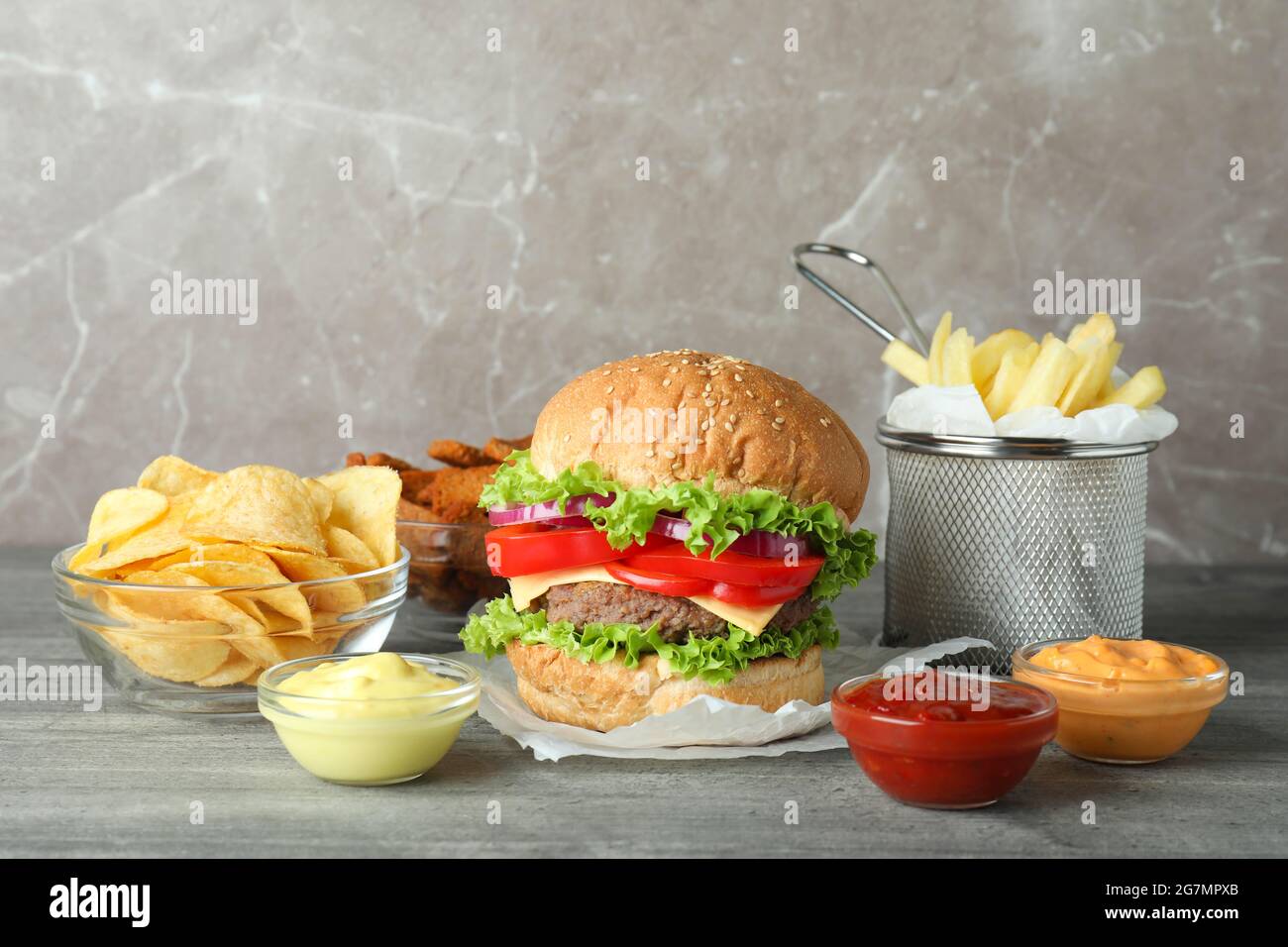 Tasty fast food on gray textured table Stock Photo - Alamy