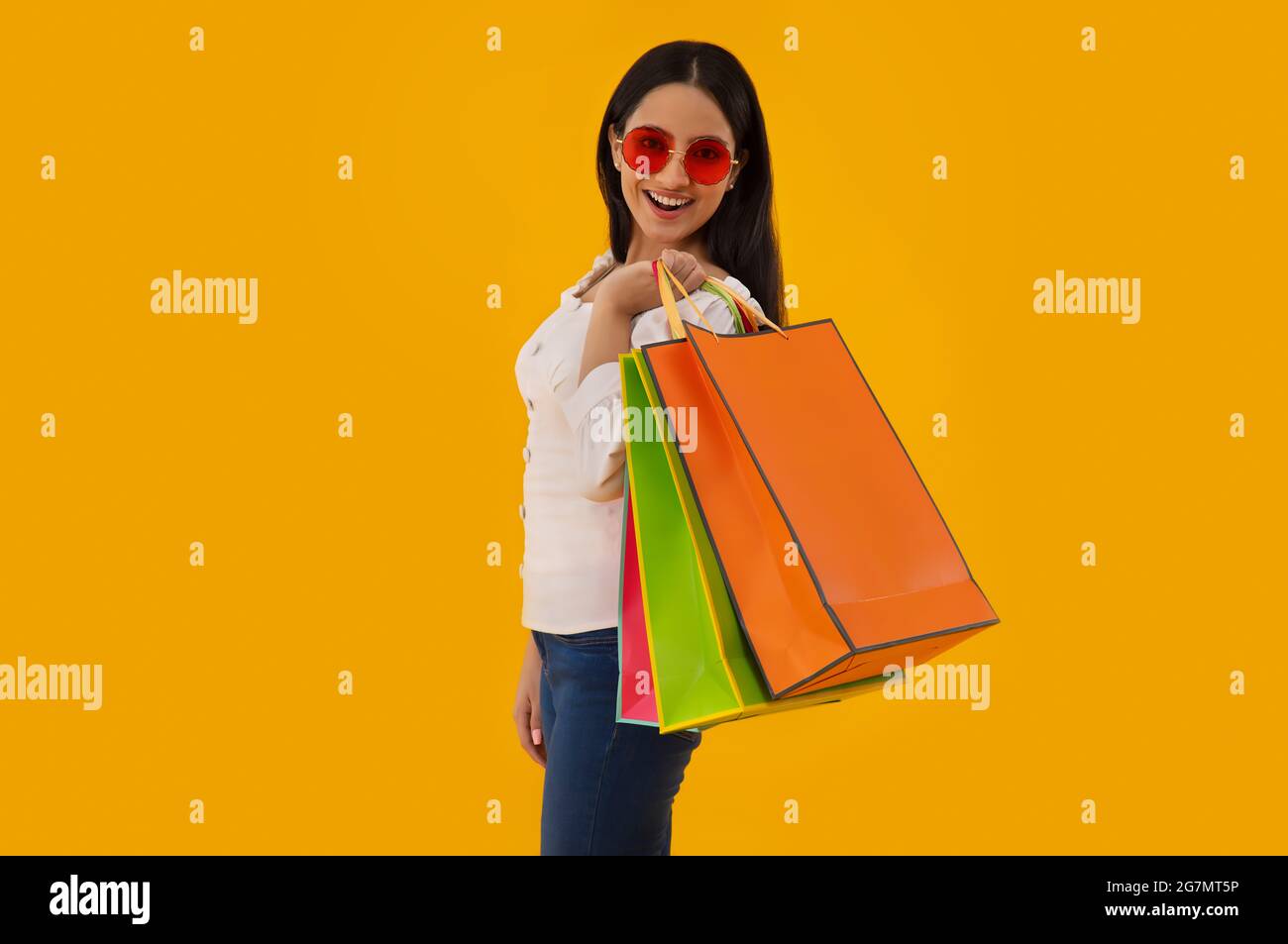 A young woman standing with Carry bags Stock Photo - Alamy