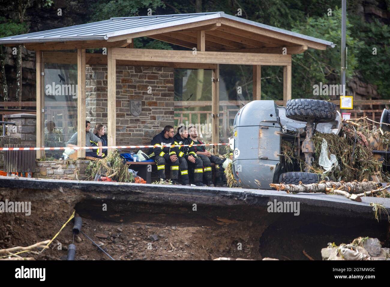 Schuld, Germany. 15th July, 2021. Firefighters take a break on a bench ...
