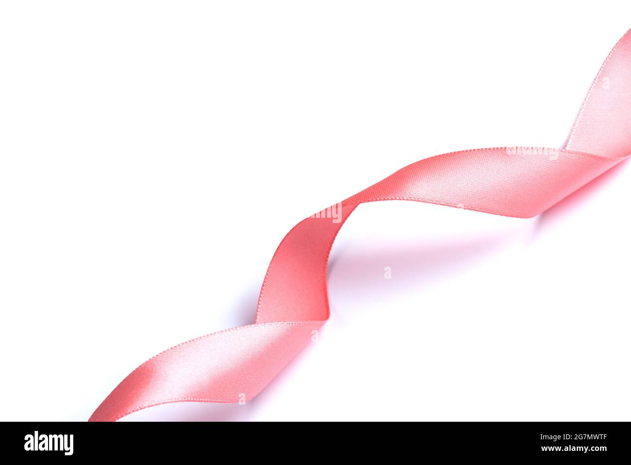 Pink silk ribbon curled on white Stock Photo - Alamy