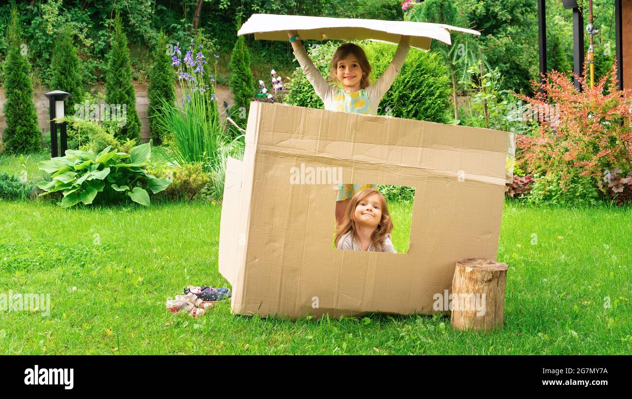 Children built a cardboard house out of a box and play in it. Real ...