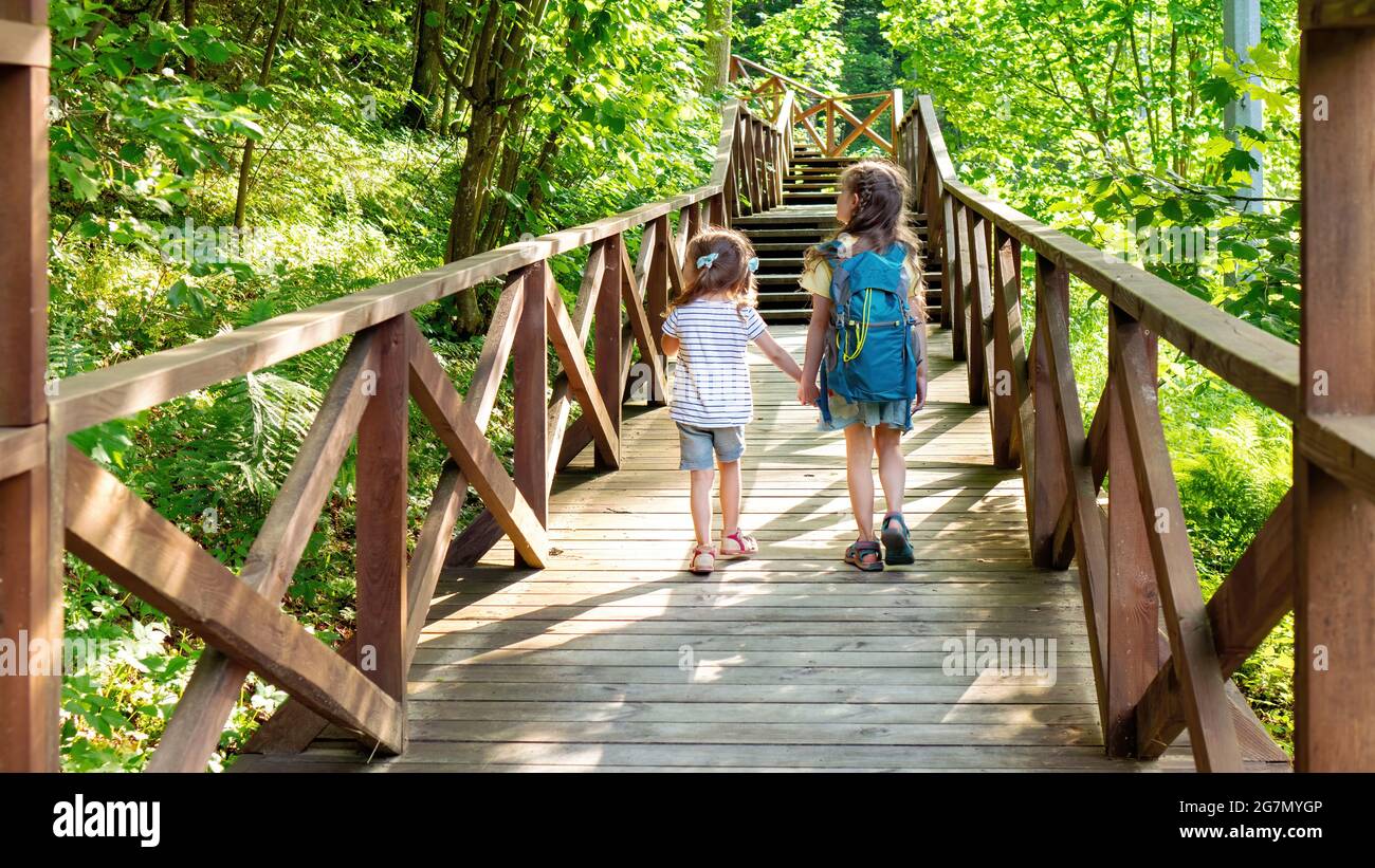 Children with backpacks walk along the hiking trail in the reserve ...