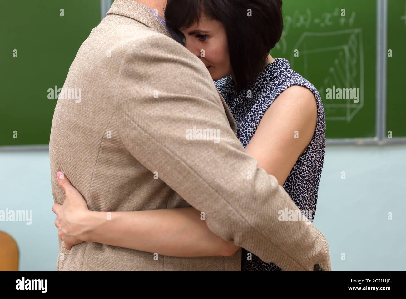 A man and a woman embrace in a school classroom at the blackboard Stock ...