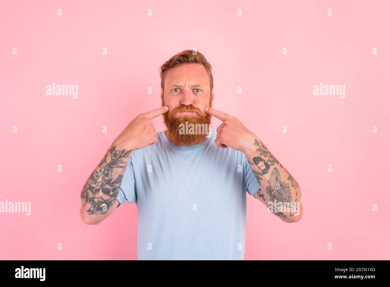 Serious man with beard and light blue t-shirt Stock Photo - Alamy