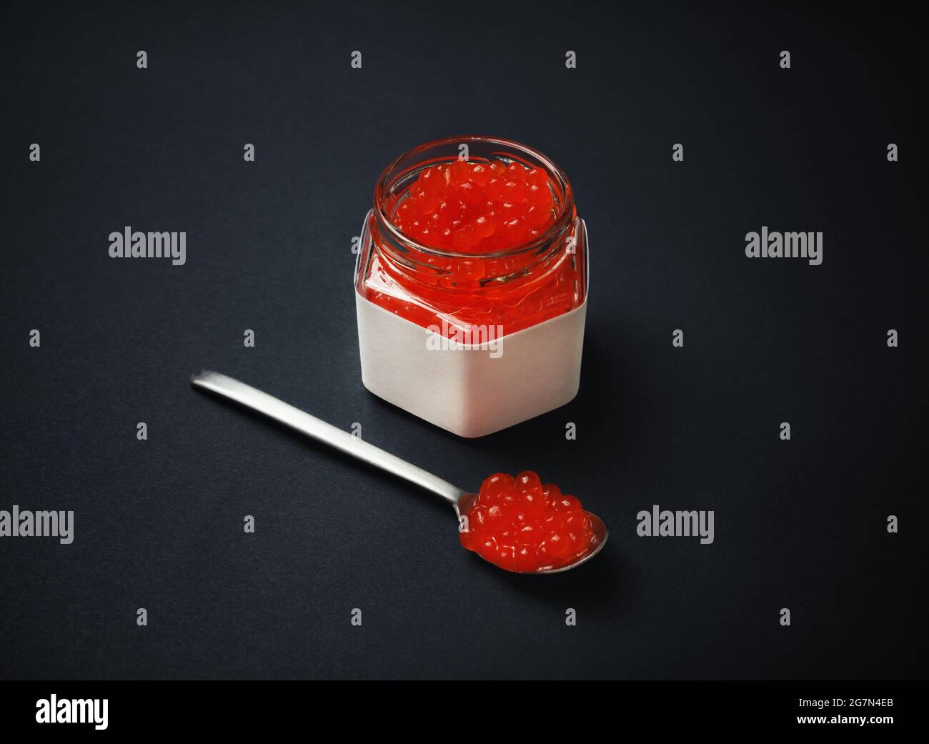 Fresh red caviar, glass jar and spoon on black background Stock Photo ...