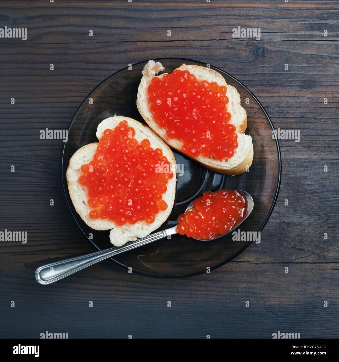 Sandwiches with red caviar, plate and spoon on wooden background. Flat ...