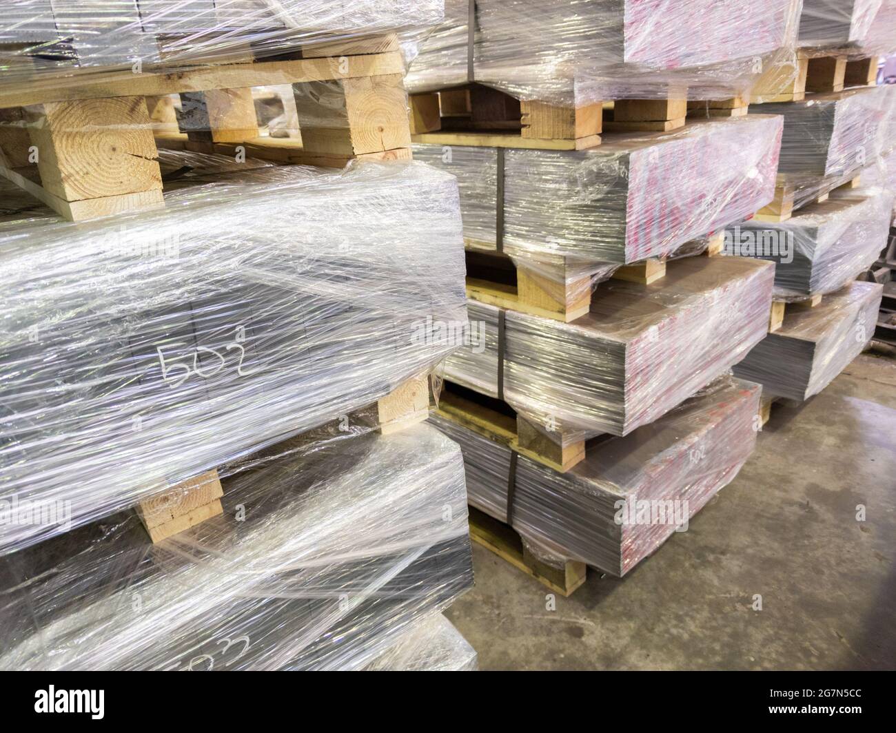 abstract industrial palleted production stacks indoors on the floor ...