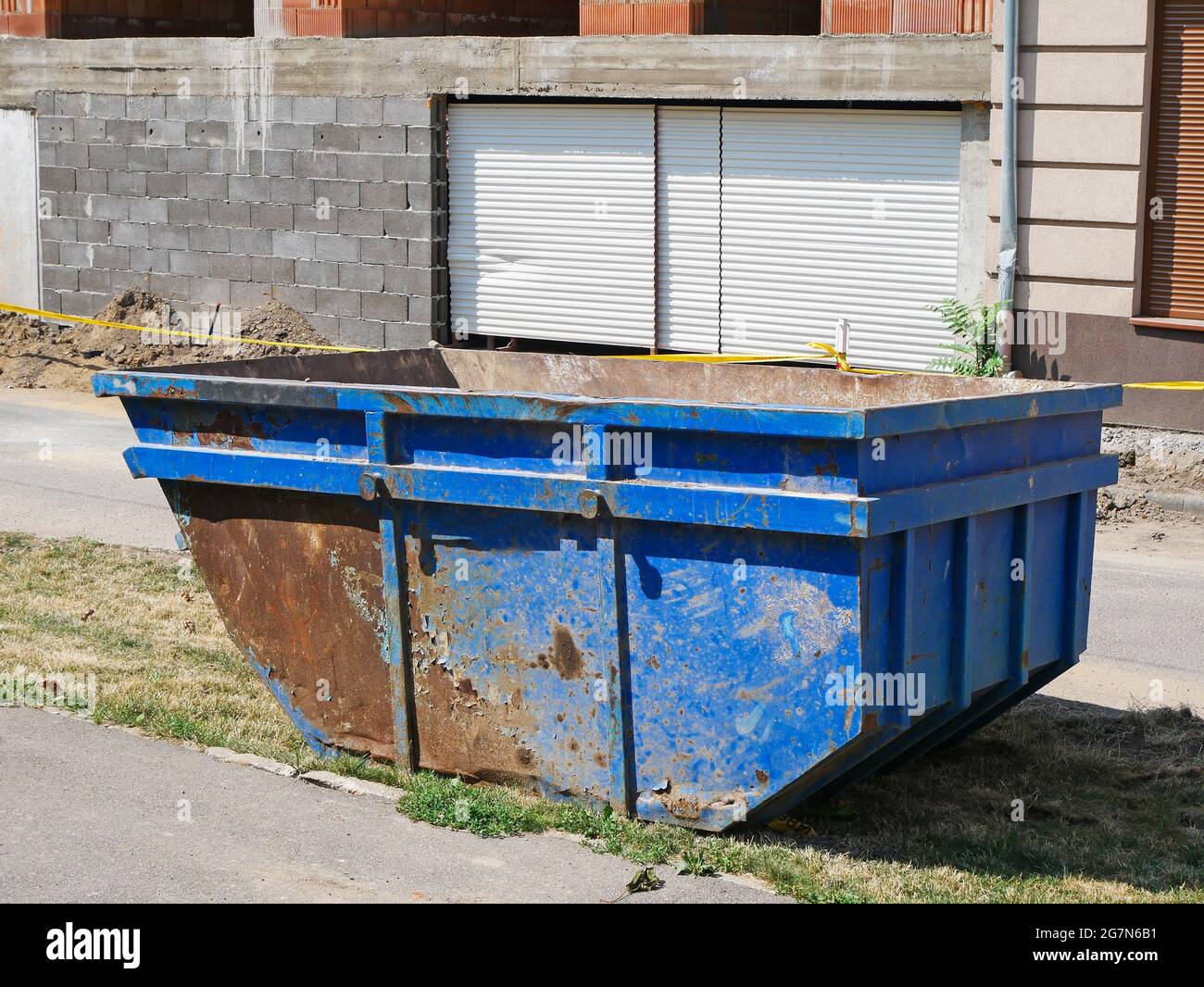 Industrial garbage can in front of a construction site Stock Photo - Alamy