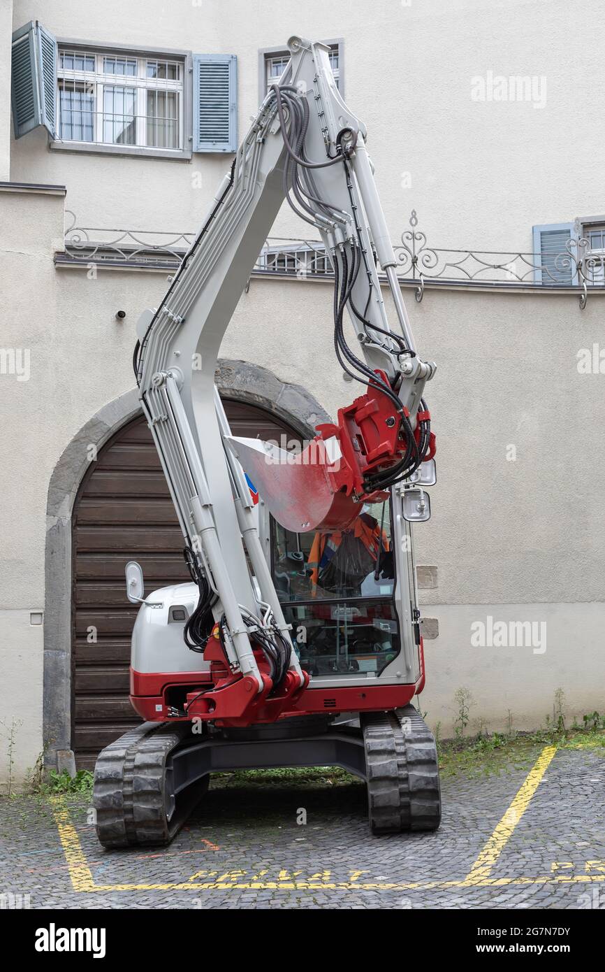 white digger on a parking spot in the city Stock Photo - Alamy
