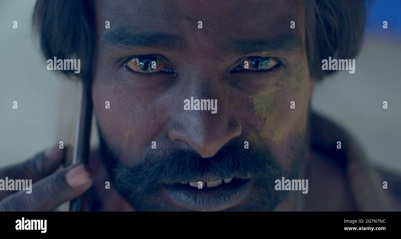 Closeup shot of an Indian beard man with a colorful face on the ...