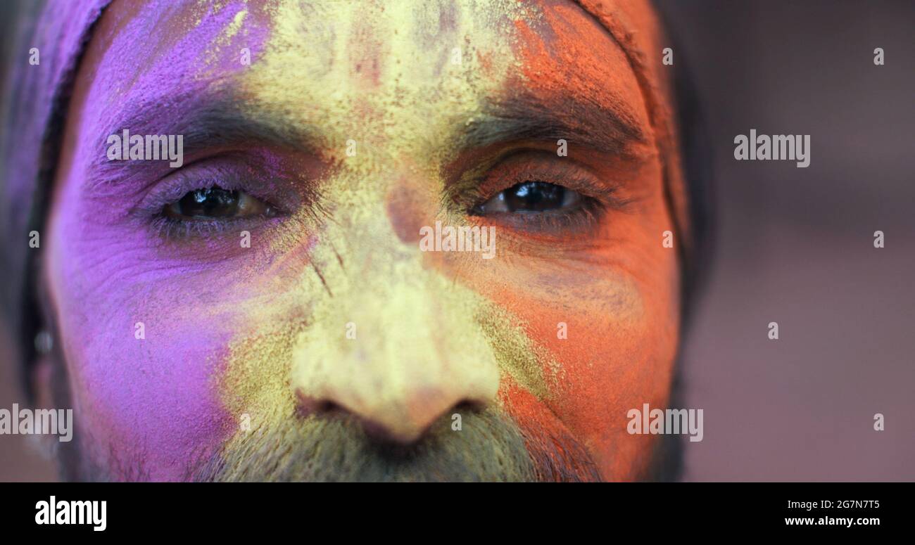 Closeup shot of an Indian beard man with a colorful face on the ...