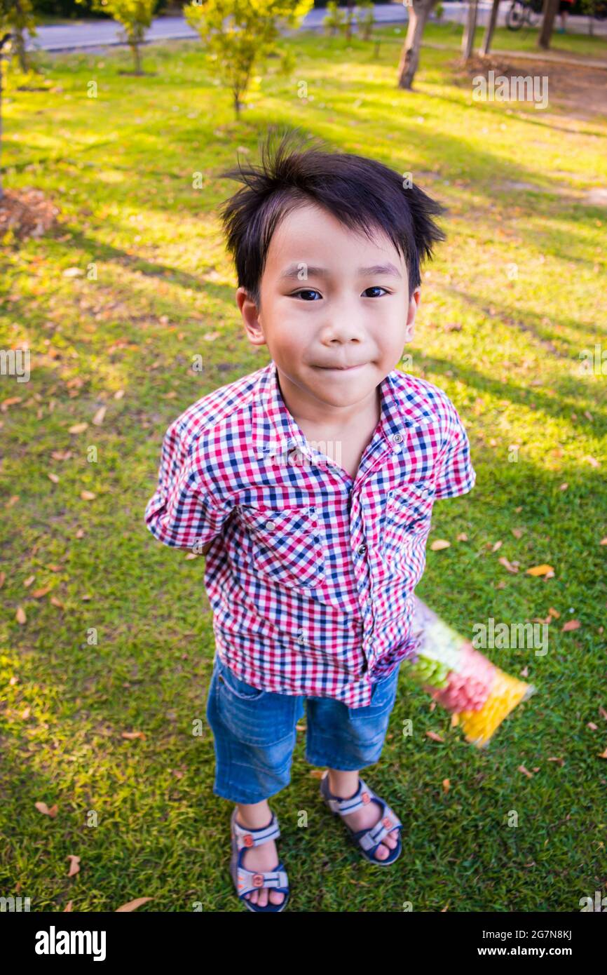 Little asian child holding colorful fish feed, cute boy smilingly and ...