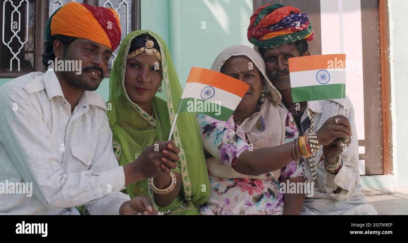 Cheerful Indian family in traditional costumes waving the National Flag ...