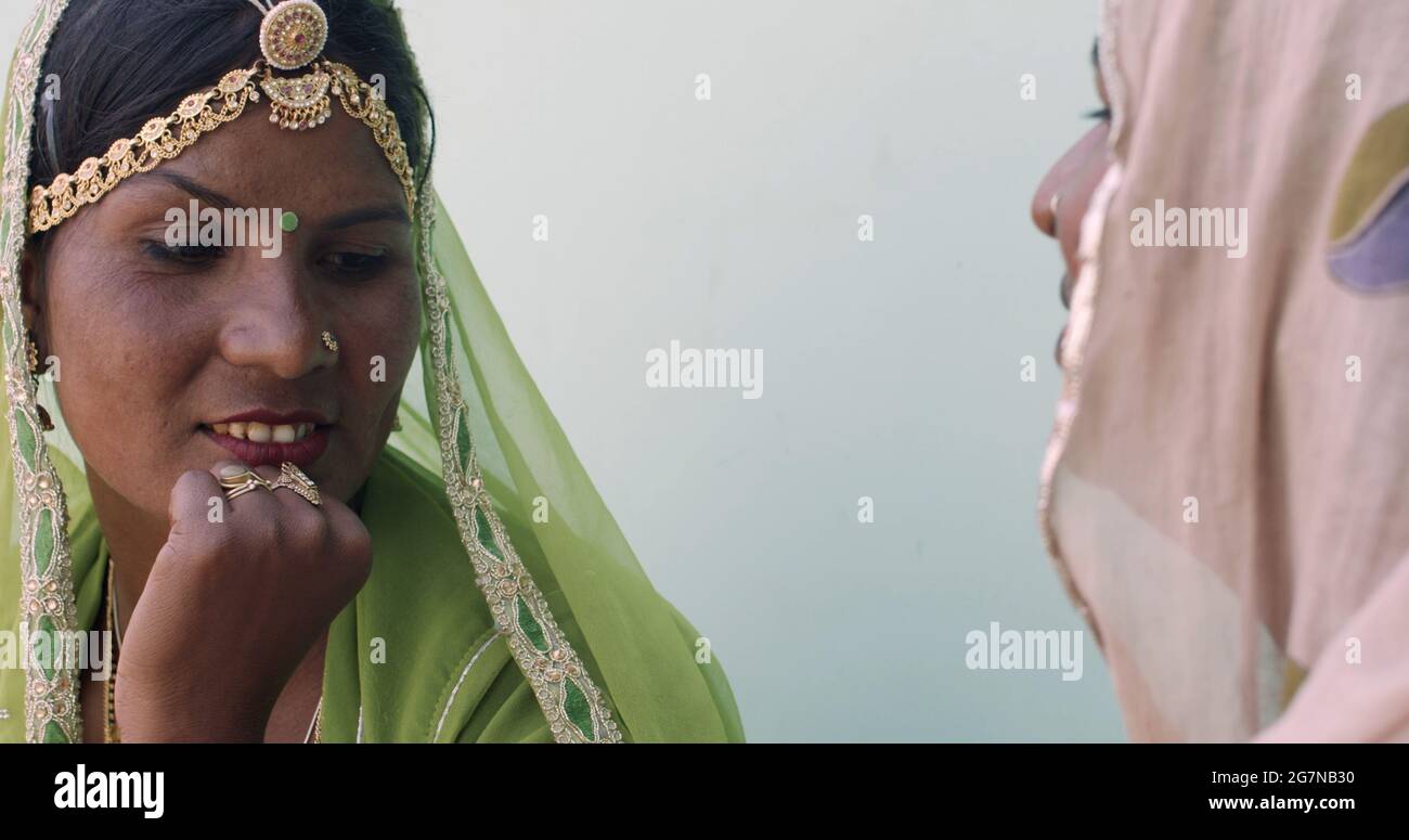 Two indian females talking to each other on white background Stock ...