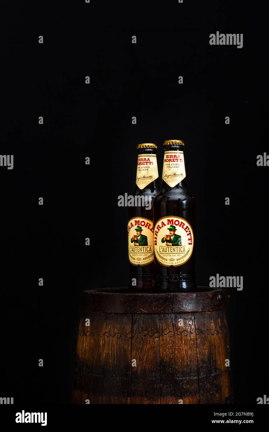 Bottle of Birra Moretti beer on wooden barrel with dark background ...