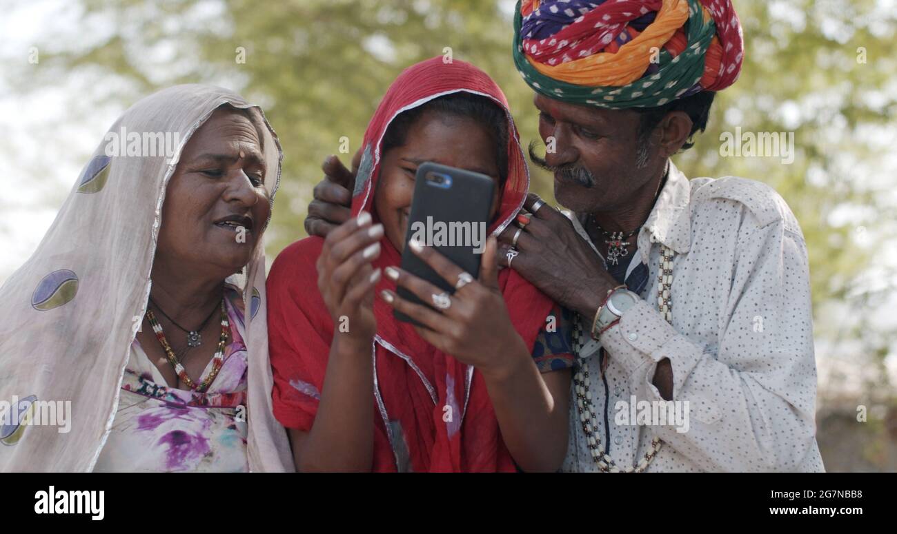 Group of South Asian people in traditional Indian clothing using a ...