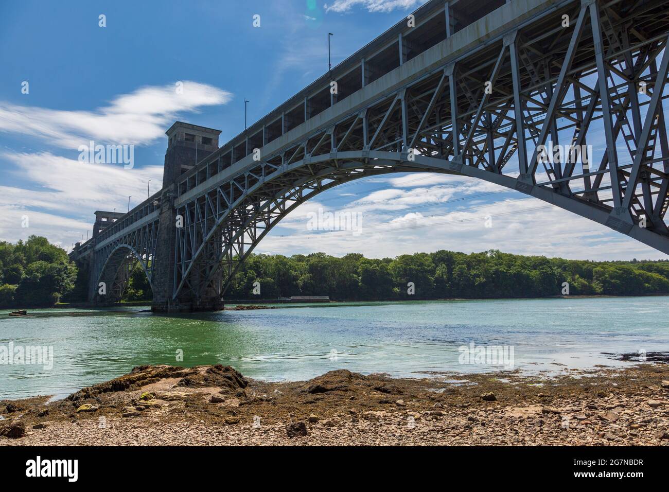 The Britannia Bridge from the shoreline of the Menai Strait at low-tide ...