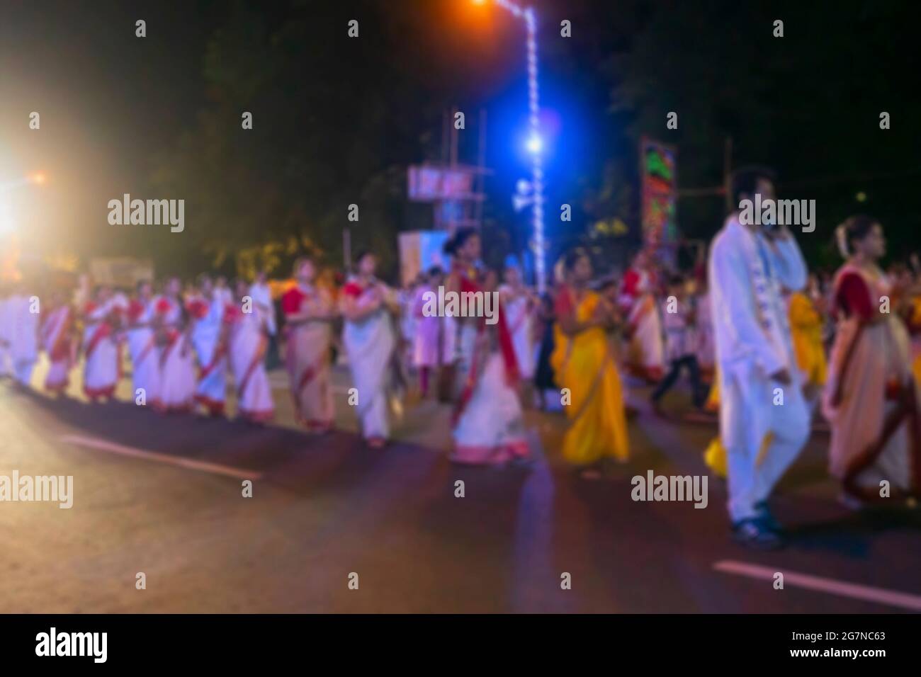 Blurred image of Bengali Hindu ladies and gentlemen dressed in red and ...