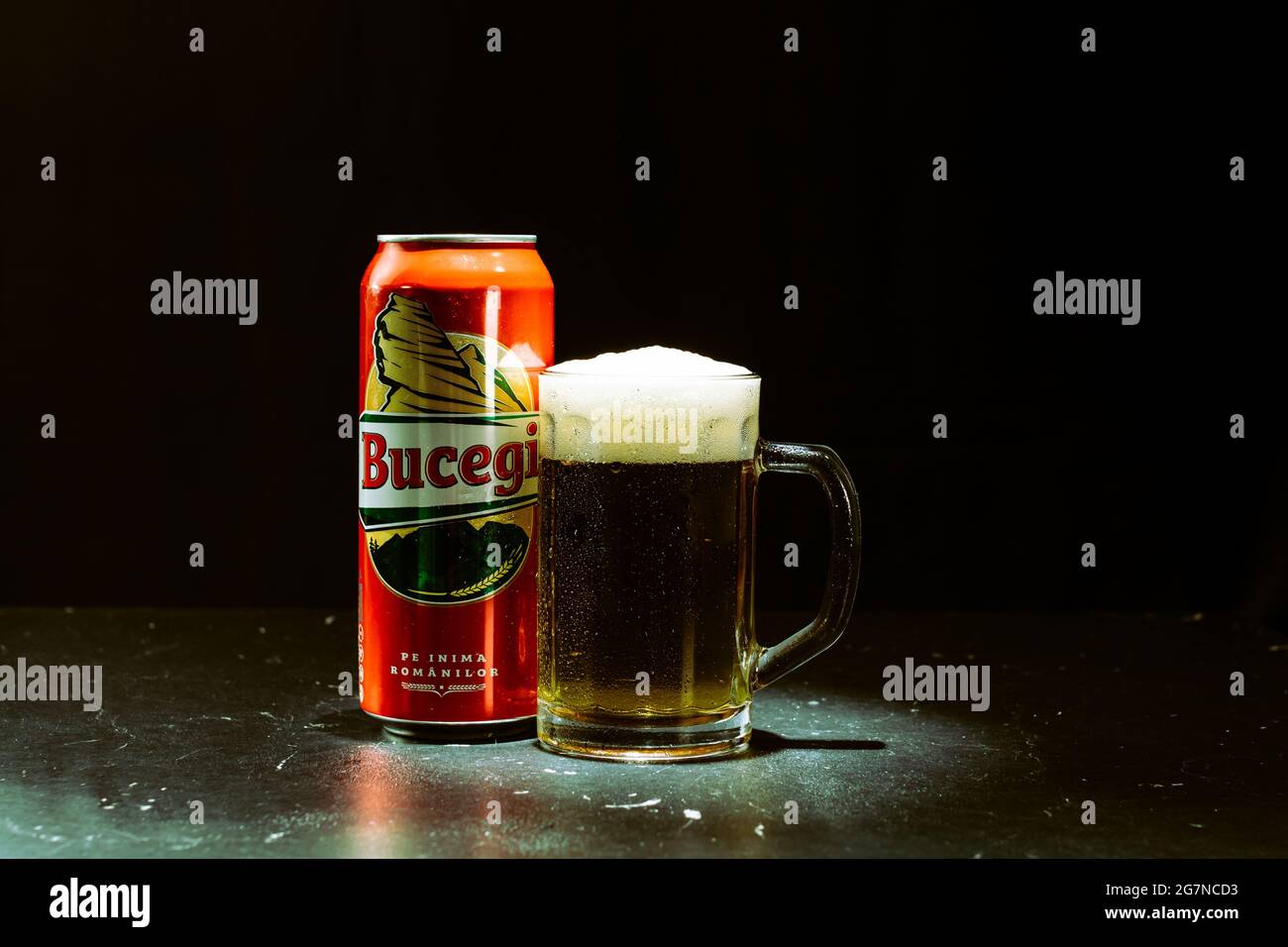 Can of Bucegi beer and beer glass on dark background. Illustrative ...
