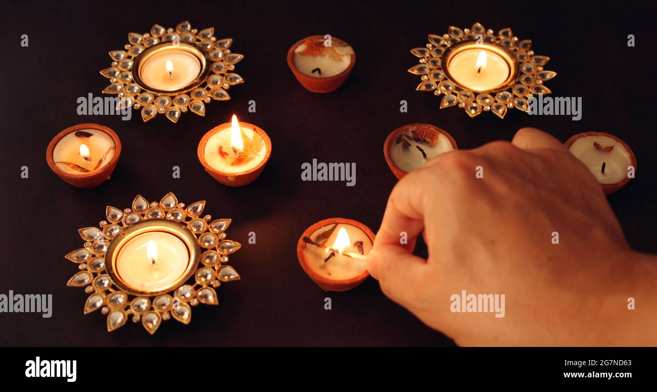 Woman's hands lighting the fire on traditional Indian wax candles Stock ...