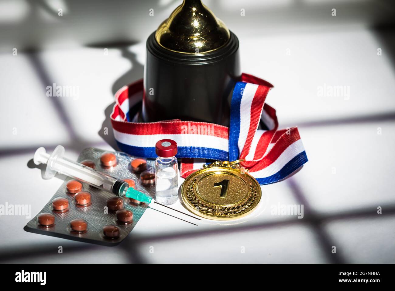 Gold medal and champion's cup, syringe with doping substance, pill tablet and vial with ...