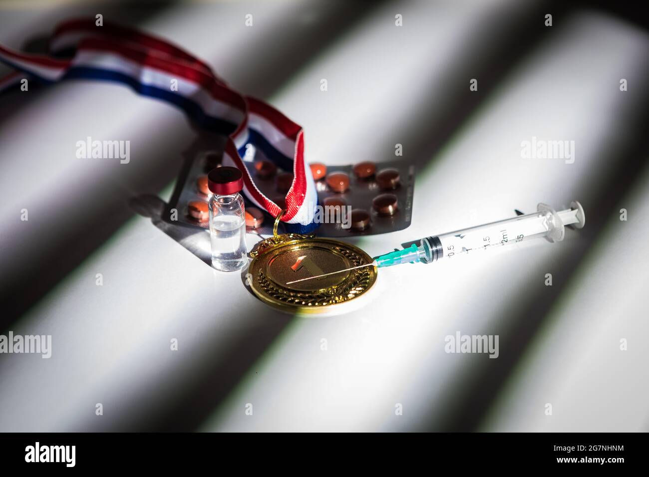 Champion's gold medal, syringe with doping substance, pill tablet and vial with prohibited ...