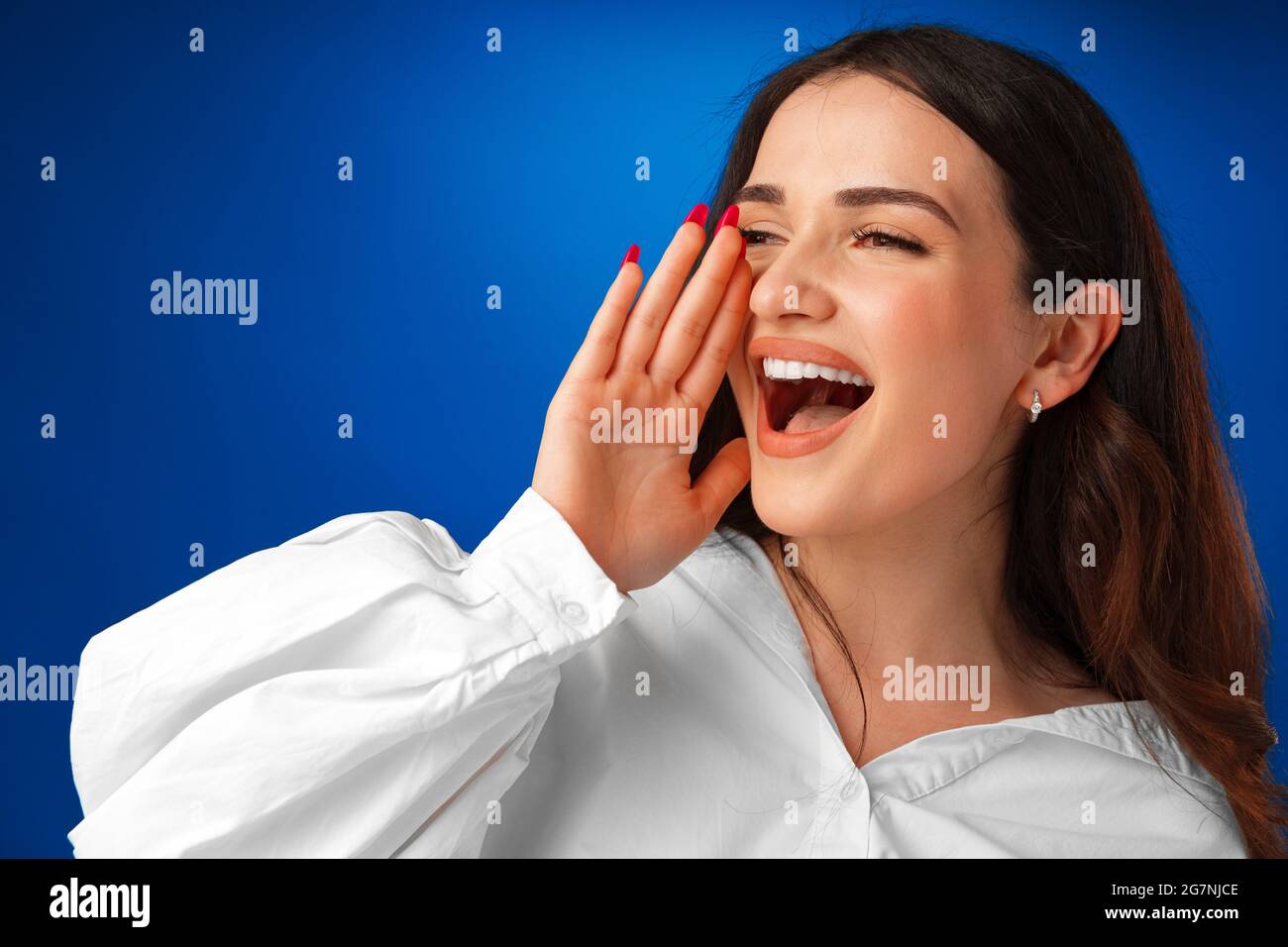 Crying emotional young woman screaming on blue studio background Stock ...