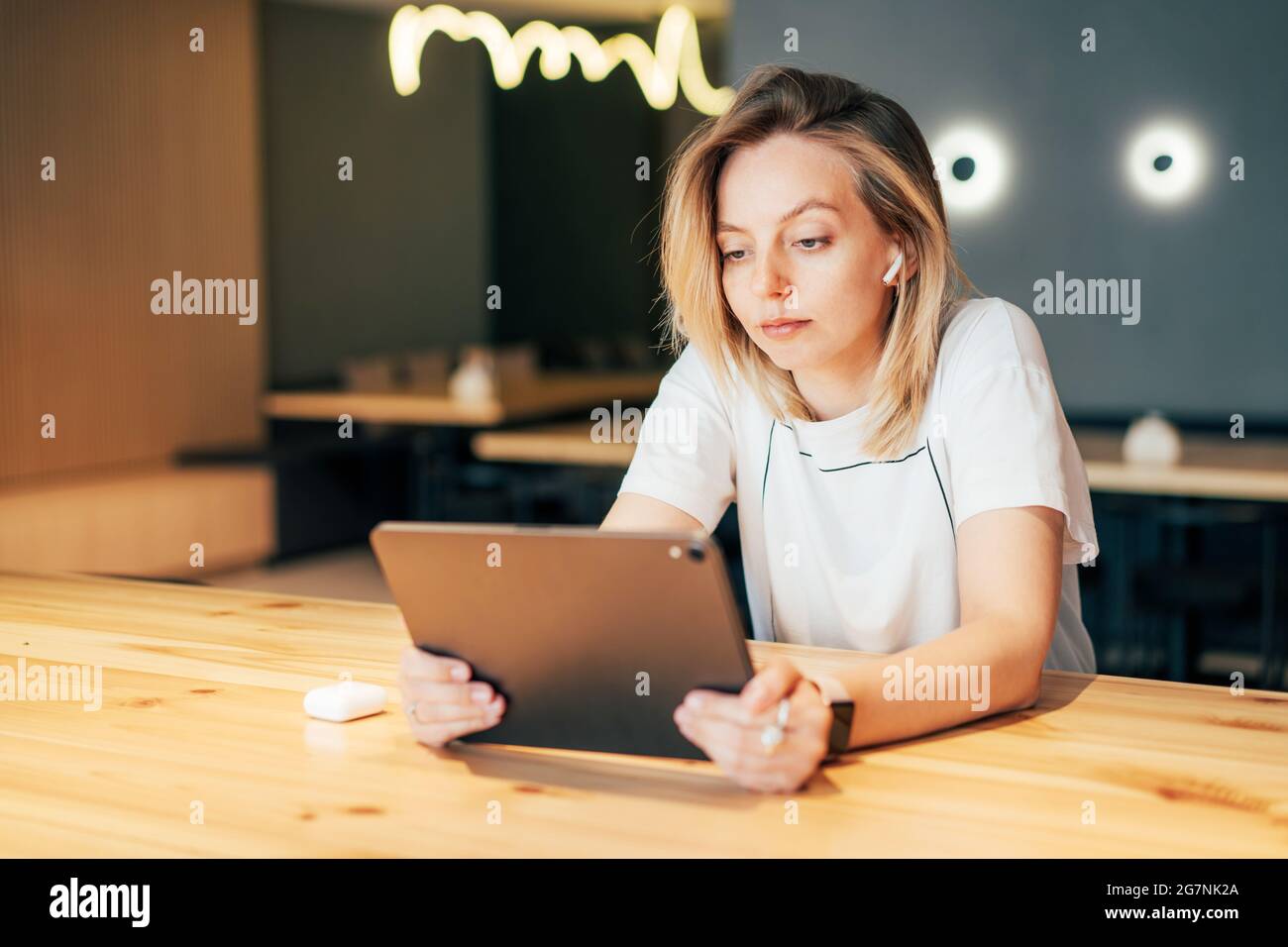Young professional woman sitting in modern coworking space uses digital ...