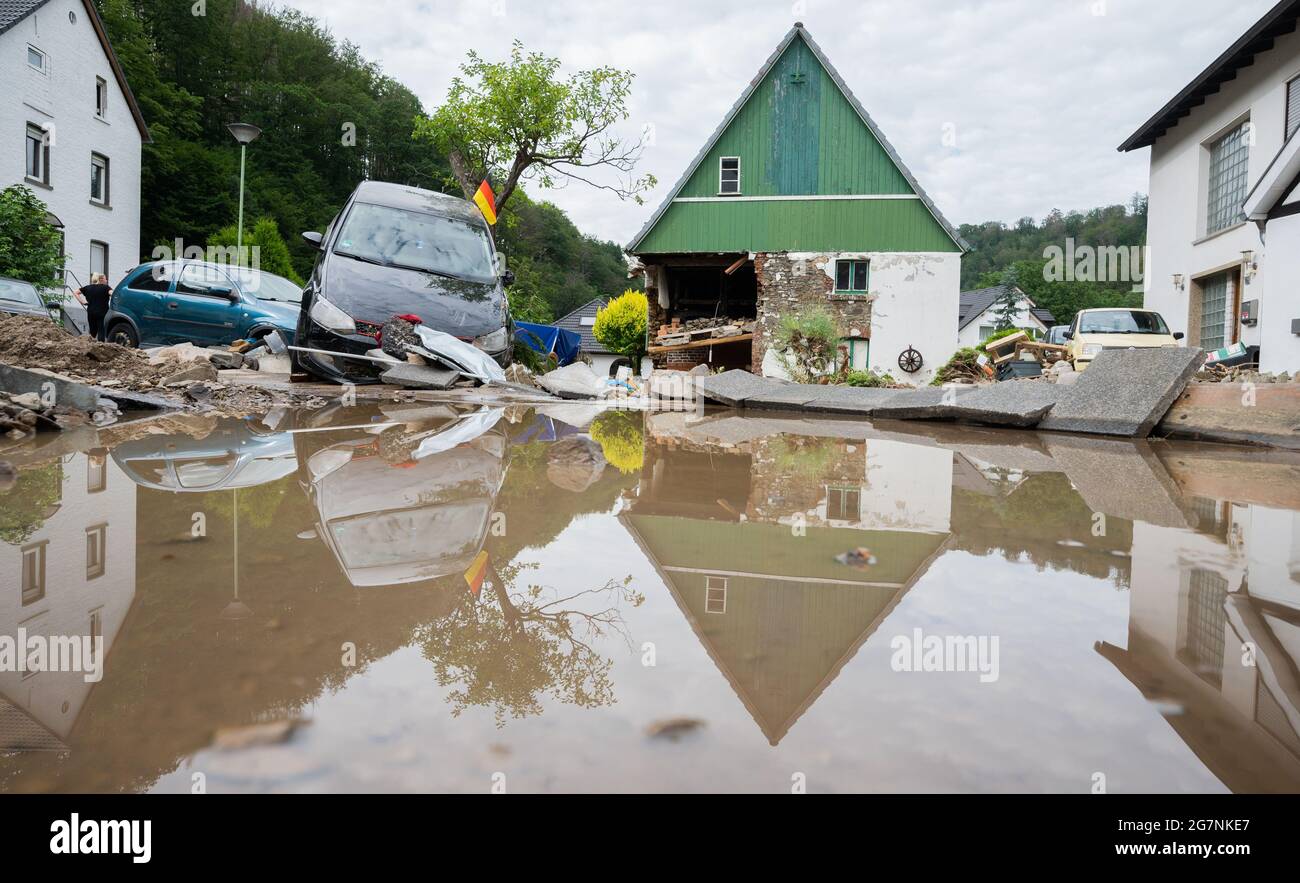 Hagen, Germany. 15th July, 2021. Storm damage is reflected in a puddle ...