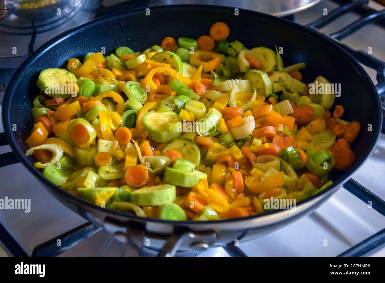 Vegetable saute in frying pan on gas stove. Process of cooking stewed ...