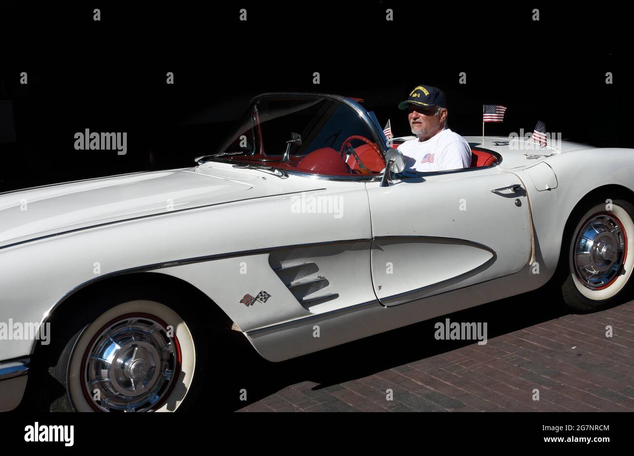 A man drives his classic 1950s Chevrolet Corvette convertible along a ...