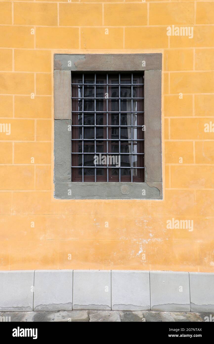 Closed square window with metal fence on stone house wall facade Stock ...