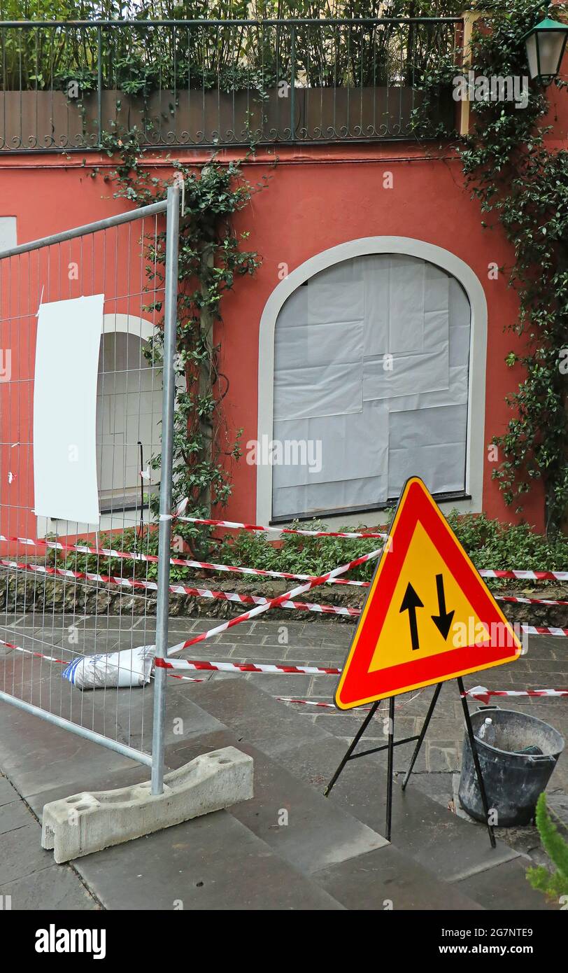 Outdoors construction works on street next to urban house with safety ...