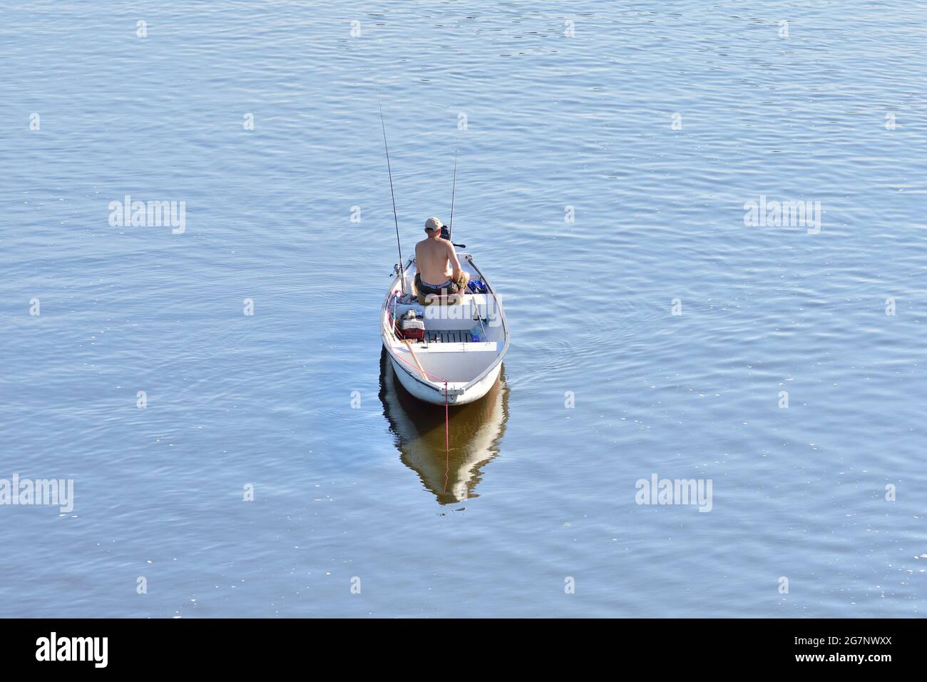 An angler on a boat is fishing on the river. Summer Stock Photo - Alamy