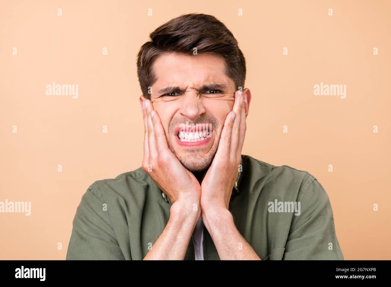 Photo of unhappy annoyed young sad man hold hands face cheekbones ...