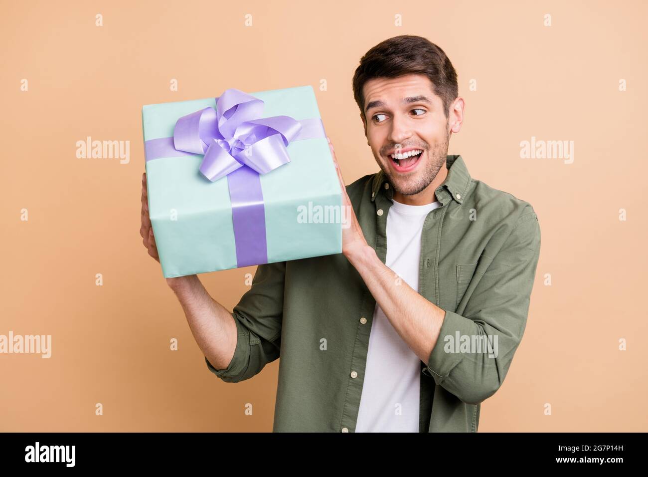 Photo of shocked excited young guy dressed green shirt trying guess ...