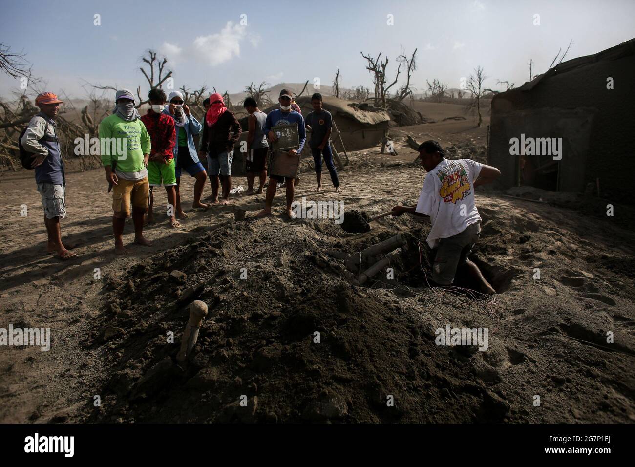 Residents save their belongings from their homes covered in ash as Taal ...