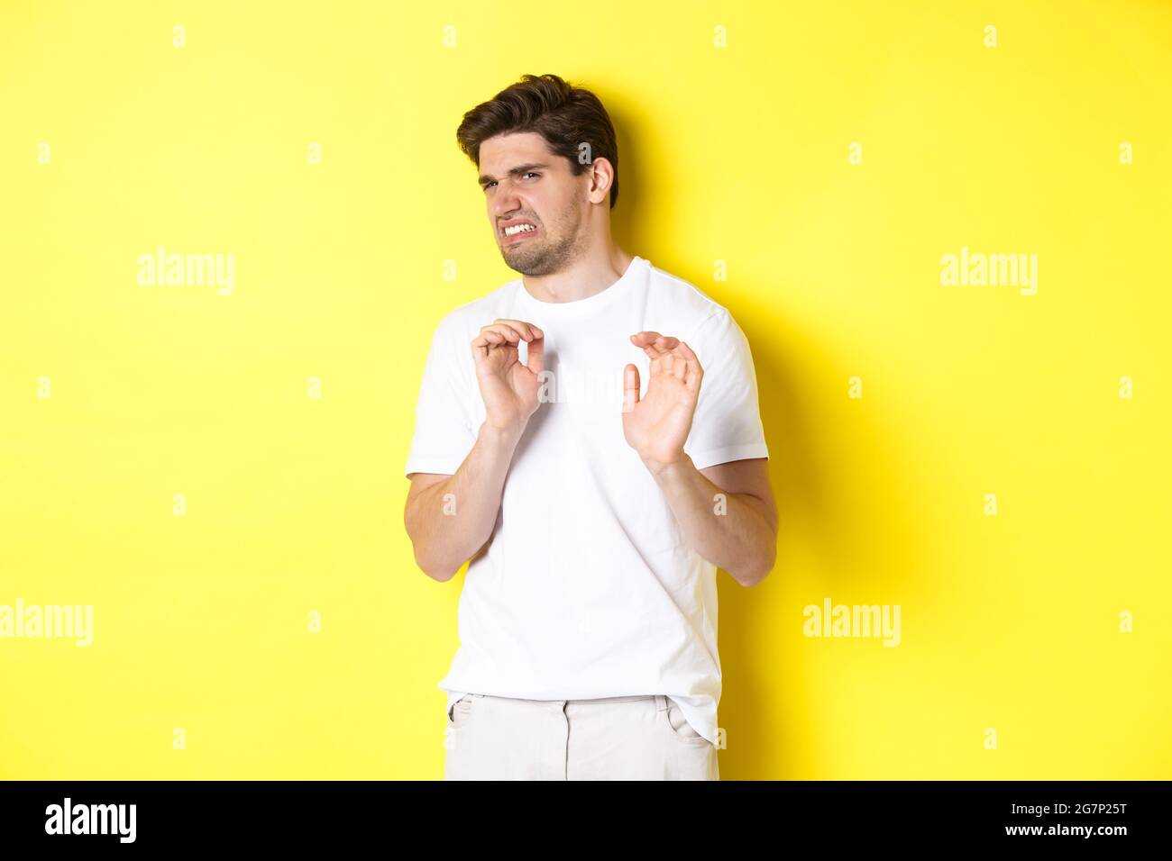 Digusted guy refusing and grimacing, looking at something with aversion ...