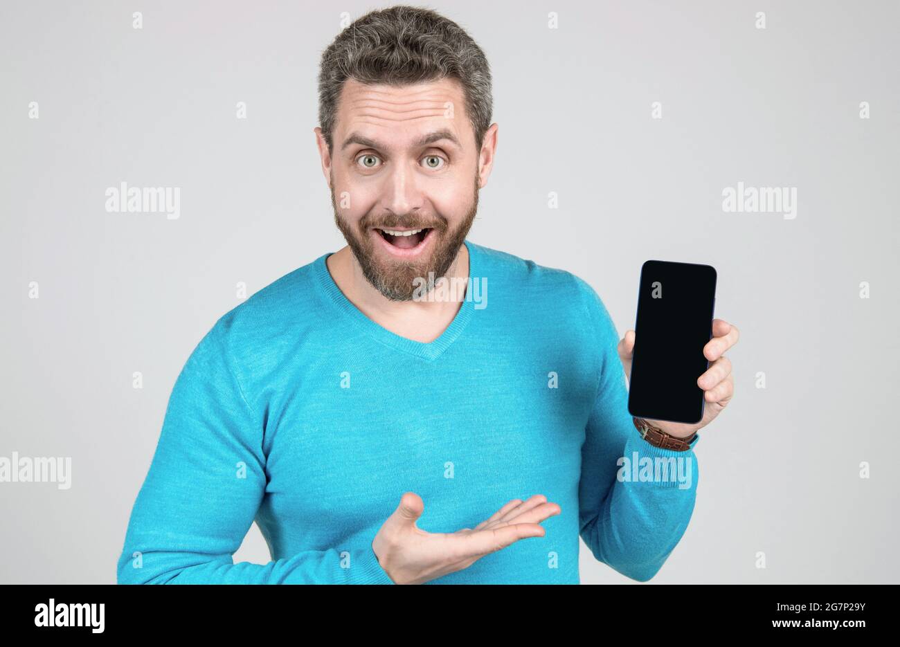 happy man with beard demonstrating smartphone, promotion Stock Photo ...