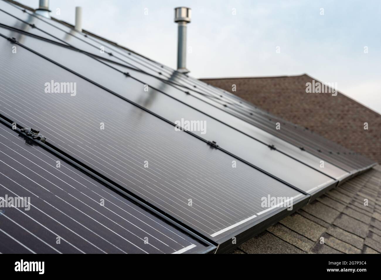 Selective focus on solar panels installed on a residential asphalt ...