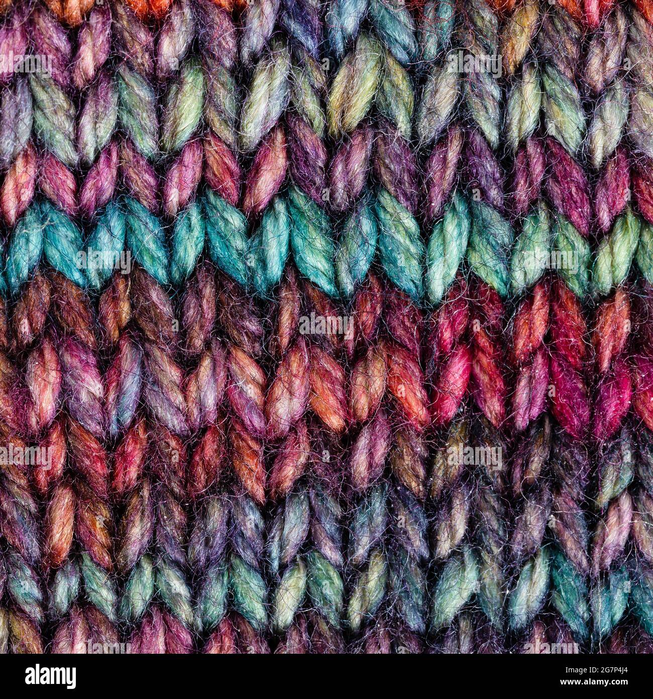textile square background - pied hand-knitted woolen cloth close up ...