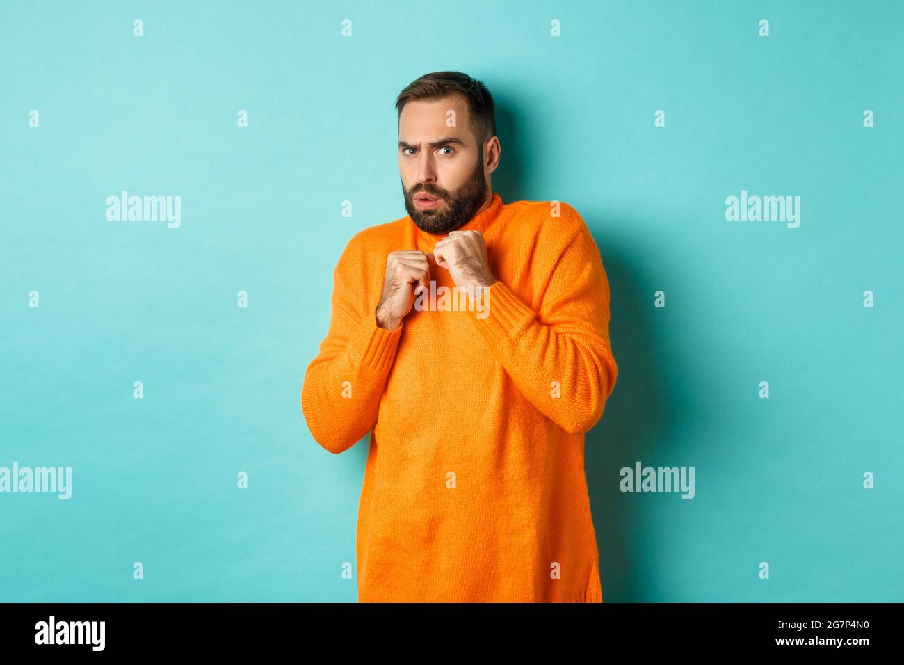 Scared guy jumping startled, looking at something scary, standing in ...