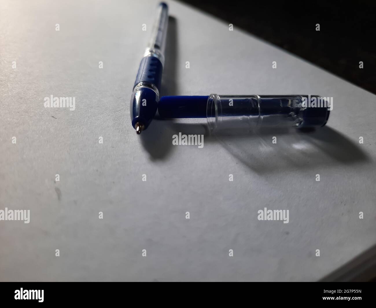 Closeup of a blue ball pen with a cap on a white surface Stock Photo ...